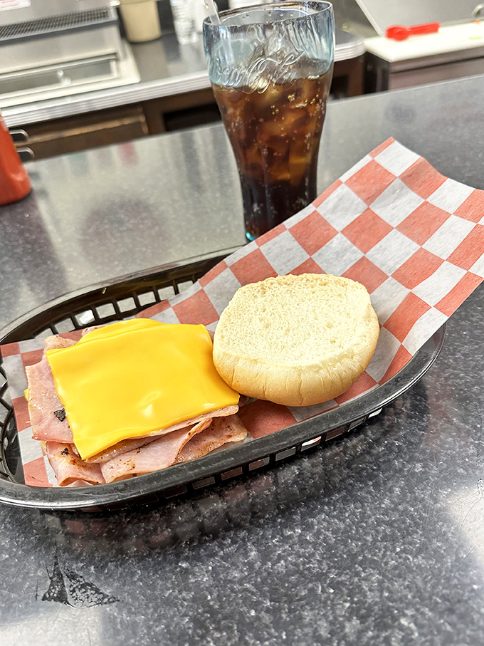 The classic American romance story: ham and cheese finding true love on a bun while a cold soda bears witness to their union.