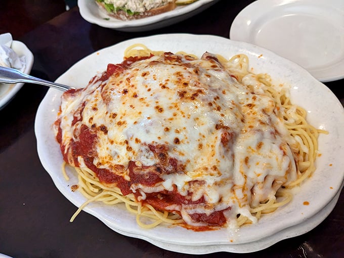 Behold the chicken parmesan in its natural habitat &ndash; swimming in marinara, blanketed with melted cheese, atop a nest of perfectly cooked spaghetti.
