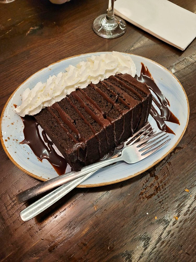 A chocolate cake so rich it probably has its own accountant. That whipped cream isn't decoration&mdash;it's necessary balance in an indulgent universe. 