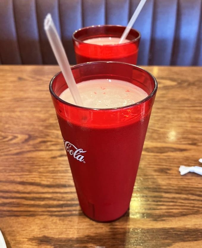 Classic Coca-Cola in those distinctive red tumblers – the kind that make every sip taste better and conversations last longer.