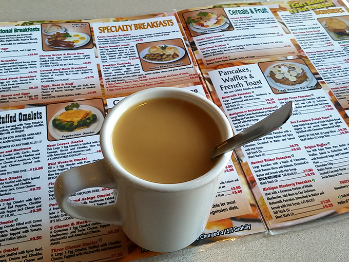 The humble coffee cup—civilization's greatest achievement—sits patiently atop a menu of possibilities, promising liquid courage for important breakfast decisions.
