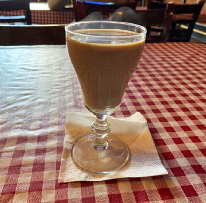 Coffee served in a proper glass, because when you're eating food this honest, your coffee shouldn't hide behind ceramic walls.