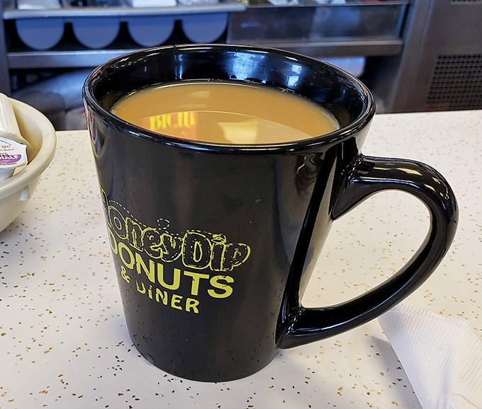 That black coffee mug with the yellow logo isn't just holding caffeine—it's holding tradition. The perfect sidekick to any breakfast adventure.