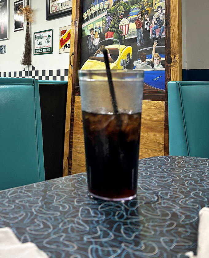 That classic soda sitting pretty against teal booth seating&mdash;some relationships are timeless, like diners and ice-cold fountain drinks. 