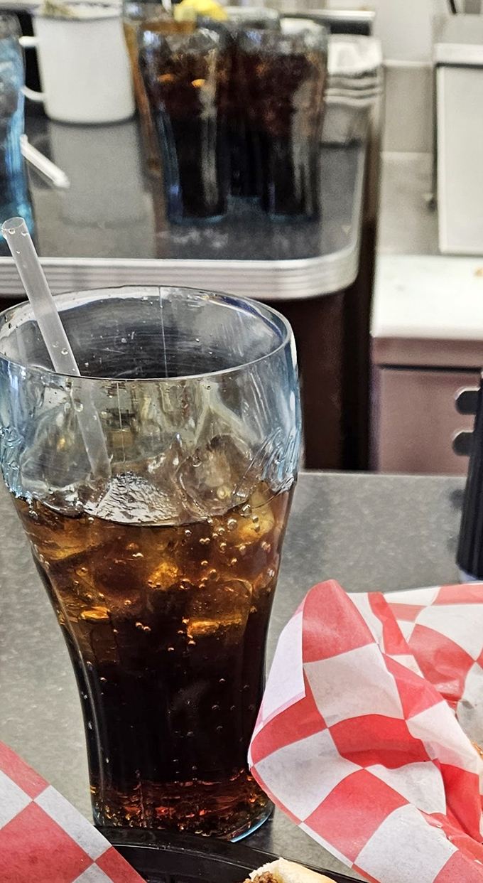 That glistening glass of cola with its perfect ice-to-soda ratio—the unsung supporting actor in every great diner experience.
