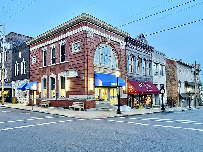 Evening settles on Court Street, where historic buildings glow with warm light and the promise of conversations waiting to happen inside.