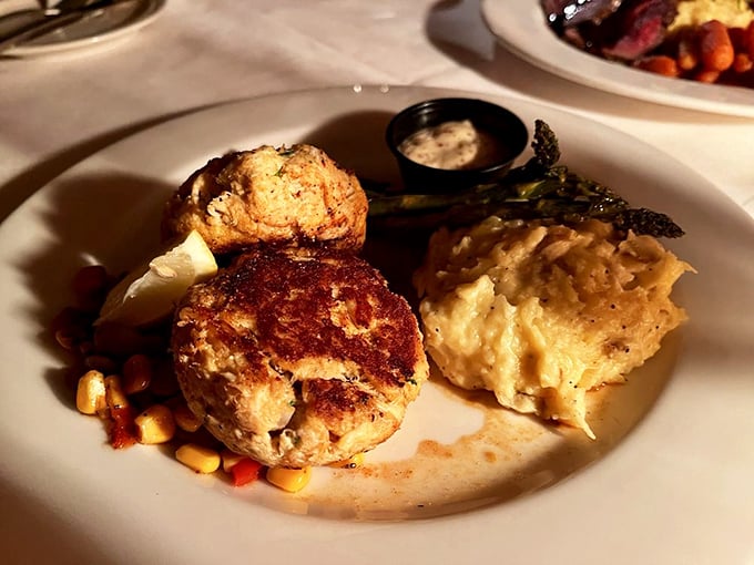 Crab cakes that are actually crab (not breadcrumbs pretending to be seafood), served alongside what appears to be the world's most comforting potato dish.