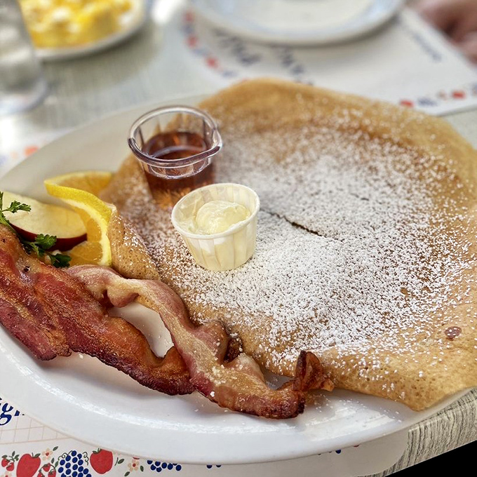 The Danish pancake arrives like a thin, golden disc of breakfast perfection. That bacon looks like it's auditioning for a food magazine cover.