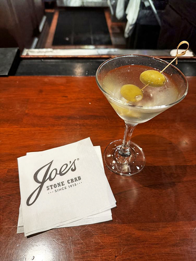 The dirty martini sits regally on its napkin throne&mdash;two olives standing guard over liquid sophistication that Don Draper would approve.