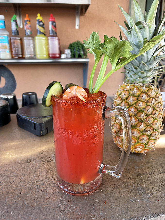 This isn't just a michelada &ndash; it's summer in a glass, with its spicy rim, fresh garnishes, and that perfect crimson hue promising refreshment.