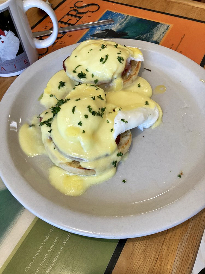Hollandaise sauce glistens like liquid gold atop these Eggs Benedict&mdash;a breakfast classic executed with the precision of a culinary Olympic event.