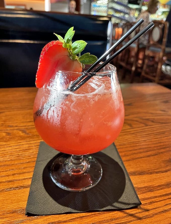 A cocktail that looks like a Tennessee sunset, garnished with fresh strawberry and mint&mdash;dangerous enough to make you forget you came for the seafood.