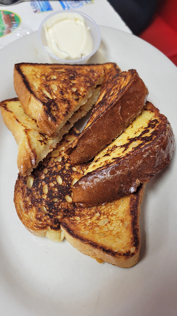 Golden-brown French toast stacked like delicious dominoes, waiting to collapse into a buttery, syrupy masterpiece on your plate.