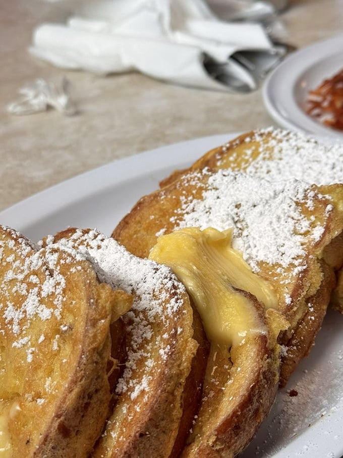 French toast that's dressed for success with a snow-like dusting of powdered sugar and a butter hat that's melting into pure breakfast bliss.