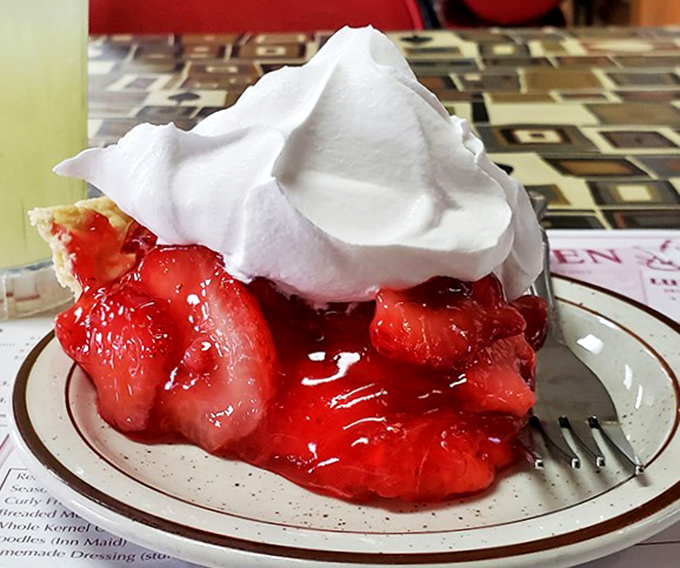 This strawberry pie isn't just dessert; it's edible artwork. That whipped cream mountain deserves its own hiking trail.