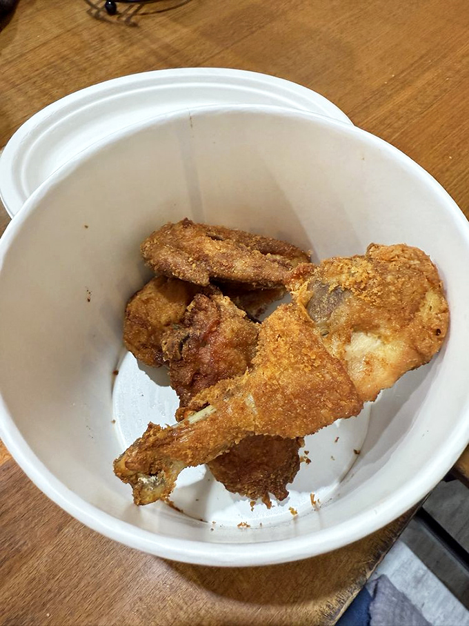 Golden-fried chicken pieces nestled in their container like delicious buried treasure, waiting to prove that simplicity done right is culinary genius.