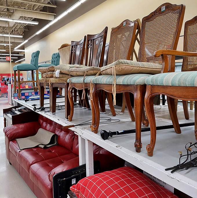 Dining chairs perch above a red leather sofa like aristocrats surveying the commoners&mdash;furniture with stories just waiting to be adopted.
