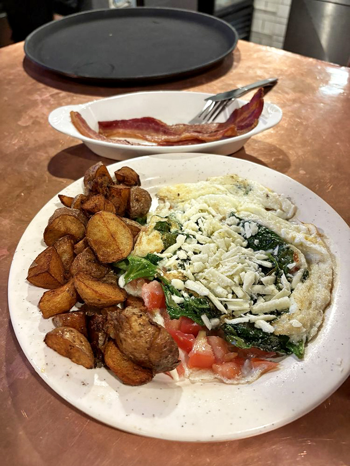 The Greek Omelette arrives like a Mediterranean vacation on a plate&mdash;spinach, tomatoes, and feta cheese creating a breakfast United Nations.