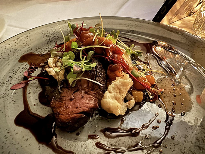 A steak presentation that makes you wonder if food stylists are hiding in the kitchen, with sauce artfully painted across the plate like a delicious Pollock.