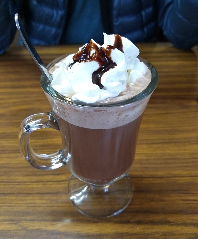 Hot chocolate that doesn't come from a packet, topped with a cloud of whipped cream and chocolate drizzle. Winter in a mug, summer be damned.