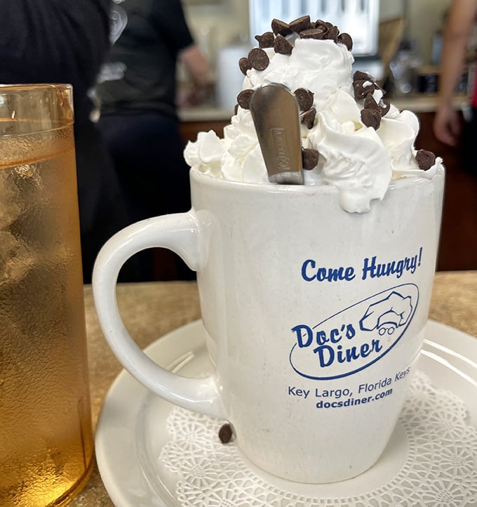 Hot chocolate topped with whipped cream and chocolate chips transforms a simple beverage into pure liquid childhood nostalgia.
