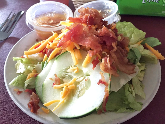 Salad before steak isn't just polite, it's strategic. Fresh greens topped with cheese, bacon, and cucumber prepare your palate for the main event.