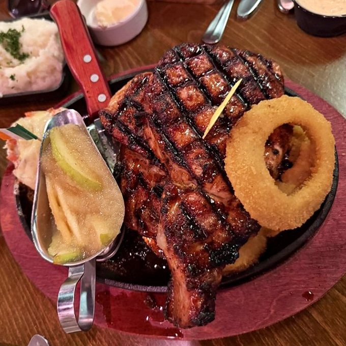 A pork chop with grill marks so perfect they deserve their own Instagram account. That onion ring isn't just a garnish—it's a golden halo of deliciousness.