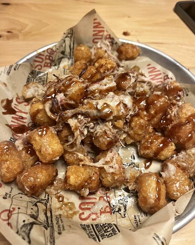 Tater tots living their best life, smothered in pulled pork and sauce. Whoever invented these clearly understood the concept of "more is more."