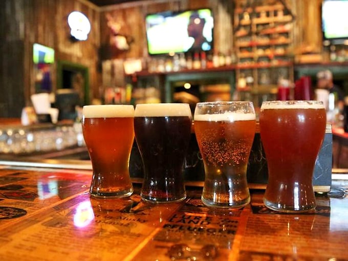A flight of local brews lined up like liquid amber jewels, each glass promising a different adventure to complement those wild game specialties.