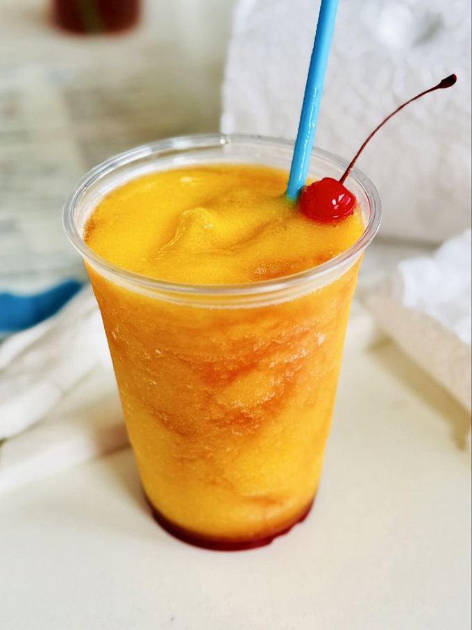 This mango daiquiri glows like liquid vacation, complete with cherry on top and endless possibilities.