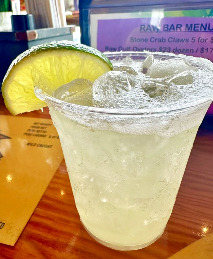 The ideal companion for seafood: a crystal-clear margarita with a lime wedge perched on the rim like a tropical sunset waiting to happen.