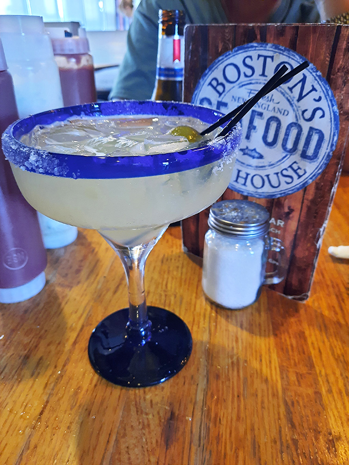 A salt-rimmed margarita beside the restaurant's logo&mdash;because nothing complements seafood quite like the bright, citrusy kick of a well-crafted cocktail.