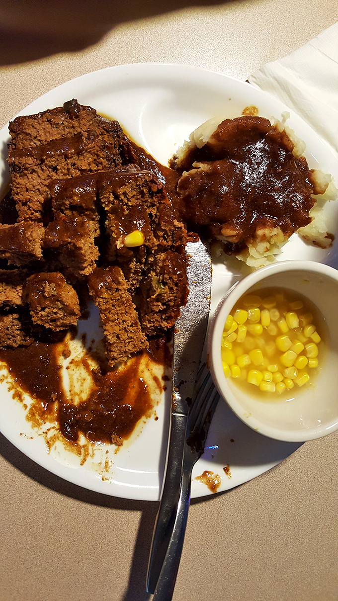 Meatloaf that would make your grandmother both jealous and proud. That gravy river flowing into mashed potato mountain is pure comfort geography.