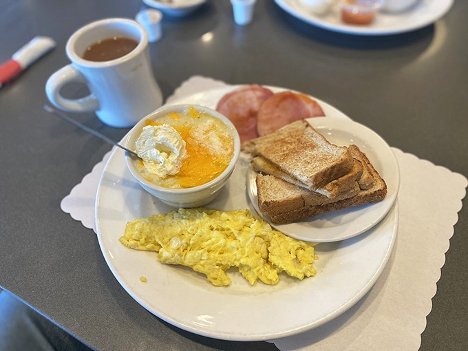 The classic American breakfast plate: where scrambled eggs, toast, and grits come together like old friends at a delicious reunion.
