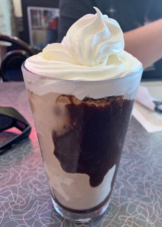 A chocolate shake tall enough to have its own zip code, with whipped cream that defies both gravity and restraint.