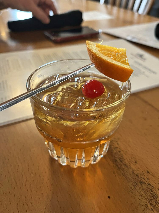 An old fashioned that would make Don Draper weep with joy. Amber perfection garnished with orange and cherry—civilization in a glass.