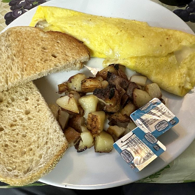 An omelet so perfectly executed it could make a French chef weep, paired with toast and potatoes that aren't just afterthoughts.