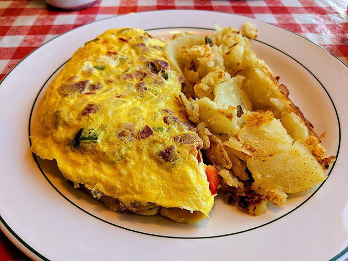 Sunshine on a plate &ndash; this omelet practically glows with eggy perfection, while home fries stand by as the faithful, crispy-edged sidekick.