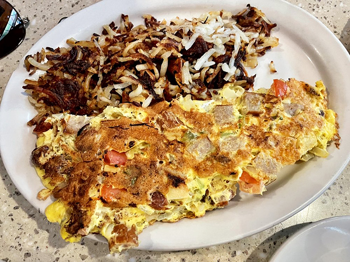 This isn't just an omelet&mdash;it's an architectural masterpiece with crispy hash browns as its foundation.