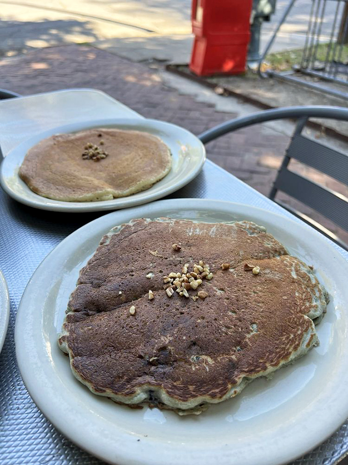Pancakes so perfectly golden they belong in a breakfast museum. Those little pecan bits aren't just toppings—they're crunchy flavor confetti.
