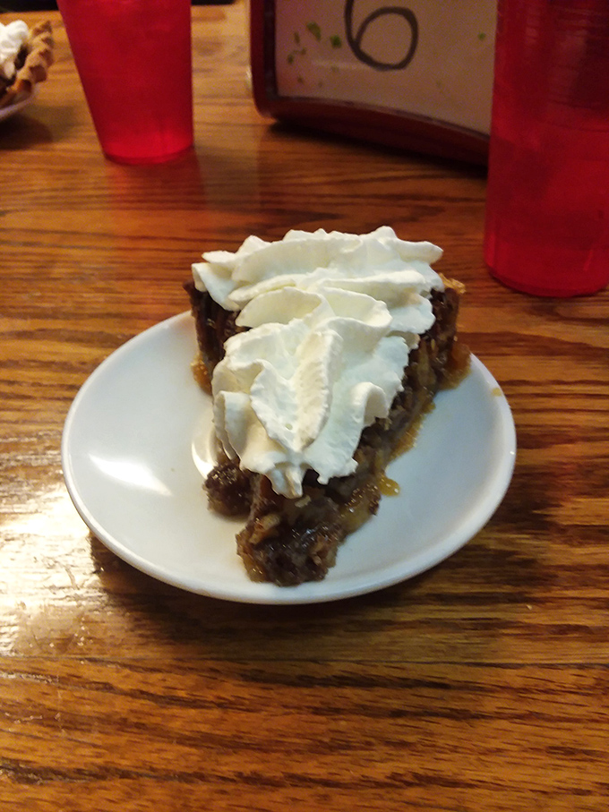 Pecan pie topped with a cloud of whipped cream&mdash;the kind of dessert that makes you seriously consider ordering a second slice "for the road."