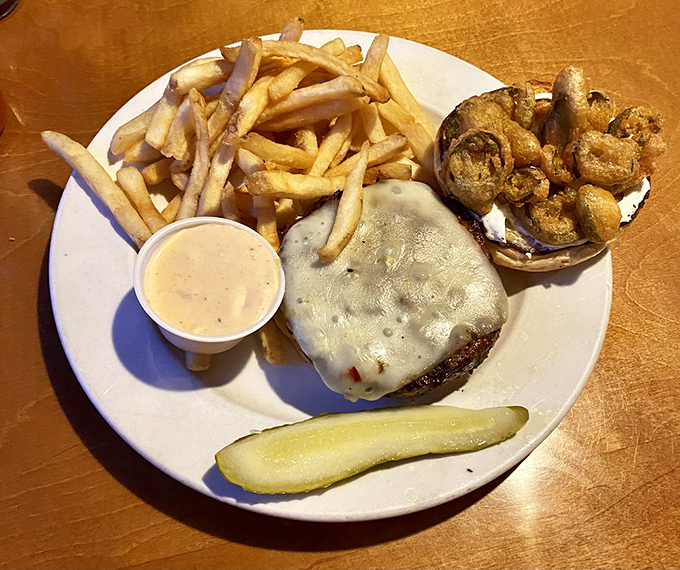 This isn't just a burger—it's a structural engineering marvel. The crispy onion ring crown and melty cheese demand both admiration and napkins.