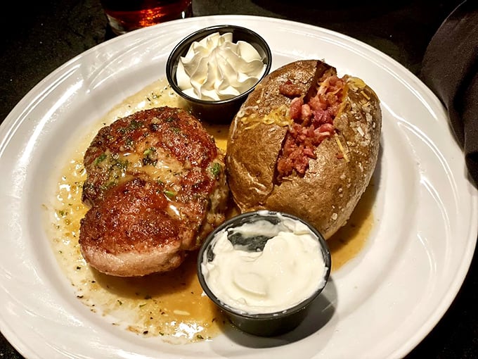 A succulent pork ribeye alongside a loaded baked potato that's dressed better than most people at the Oscars.