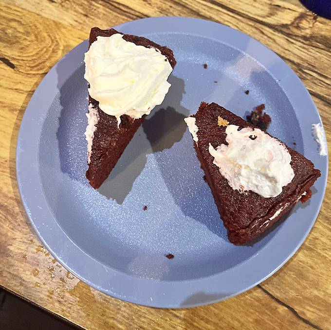 Red velvet cake so moist it should require a lifeguard. That whipped cream isn't just a topping&mdash;it's the cloud this dessert deserves to float on.