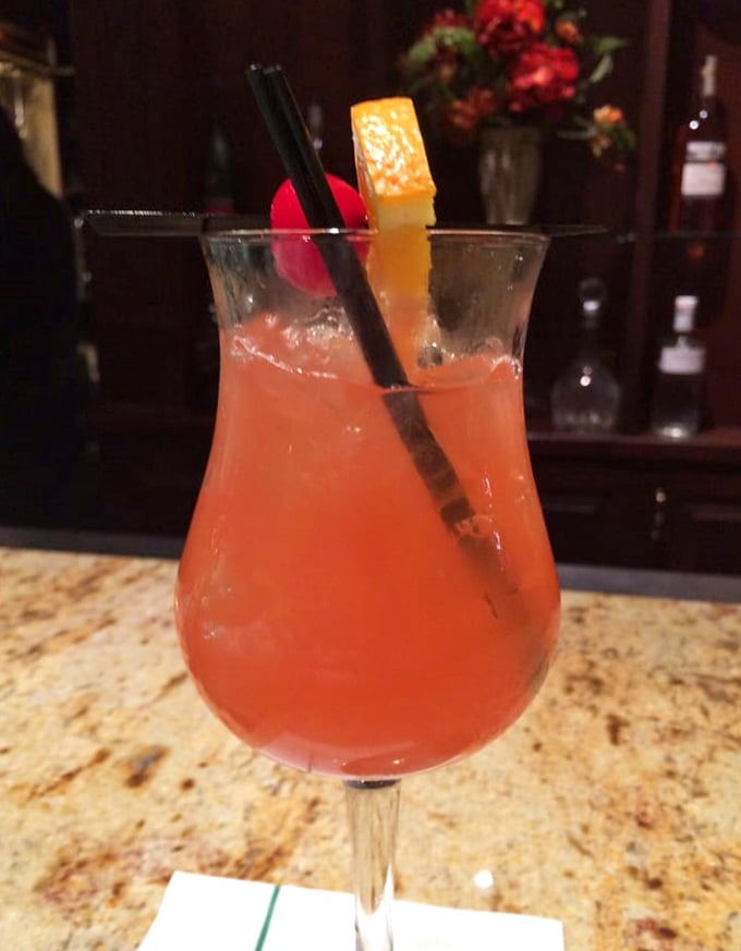 A rum runner cocktail that glows like a Pennsylvania sunset, garnished with fruit and promising vacation vibes even on a Tuesday.