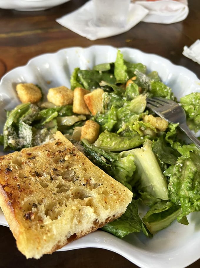 Even the salad gets the VIP treatment with a side of garlic bread that's clearly been invited to steal the show.