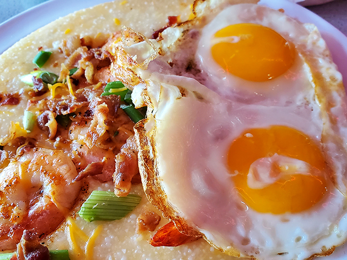 Two sunny eggs keeping watch over a landscape of creamy grits and succulent shrimp&mdash;a Southern breakfast masterpiece that belongs in the Louvre.