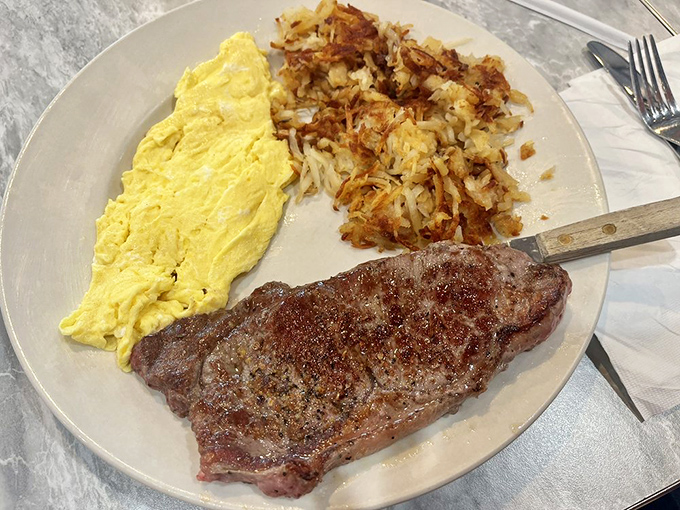 Breakfast of champions: a perfectly seared steak alongside fluffy scrambled eggs and crispy hash browns. Who needs dinner when this is available at 7am?