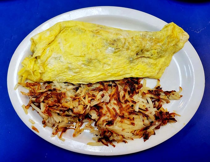 That perfect omelet fold—a culinary origami housing savory treasures, while those hash browns achieve the golden-crisp ideal.