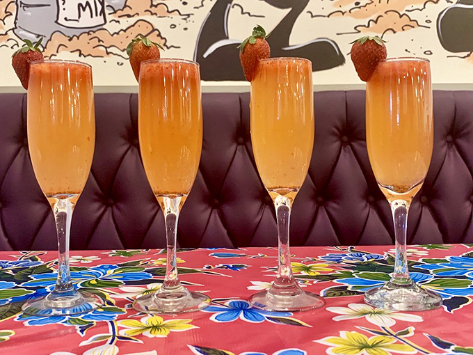 Strawberry-topped mimosas lined up like liquid sunshine ready to make any morning feel like celebration time.
